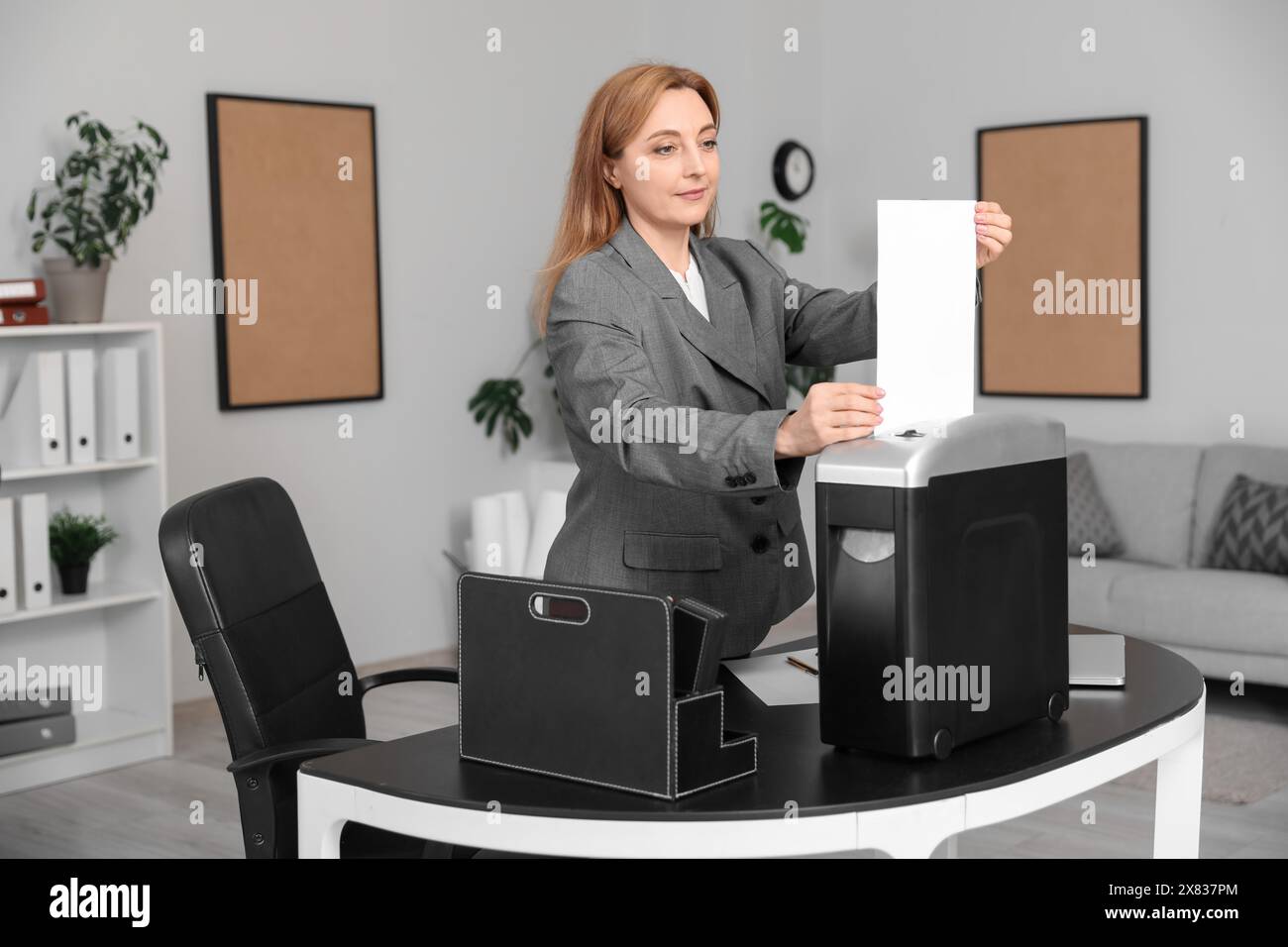 Adult secretary destroying paper sheet using shredder in office Stock ...