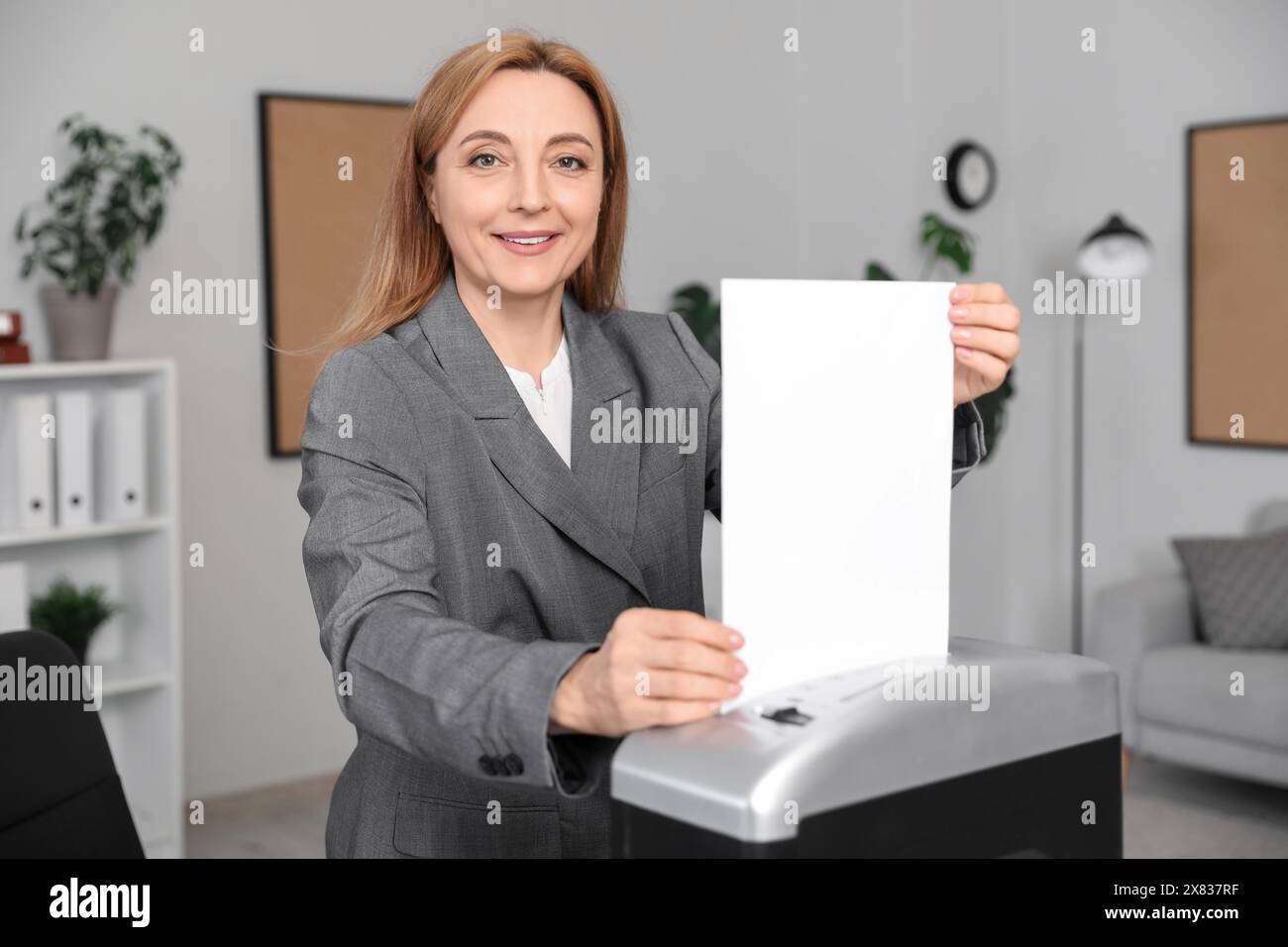 Adult secretary destroying paper sheet using shredder in office Stock ...