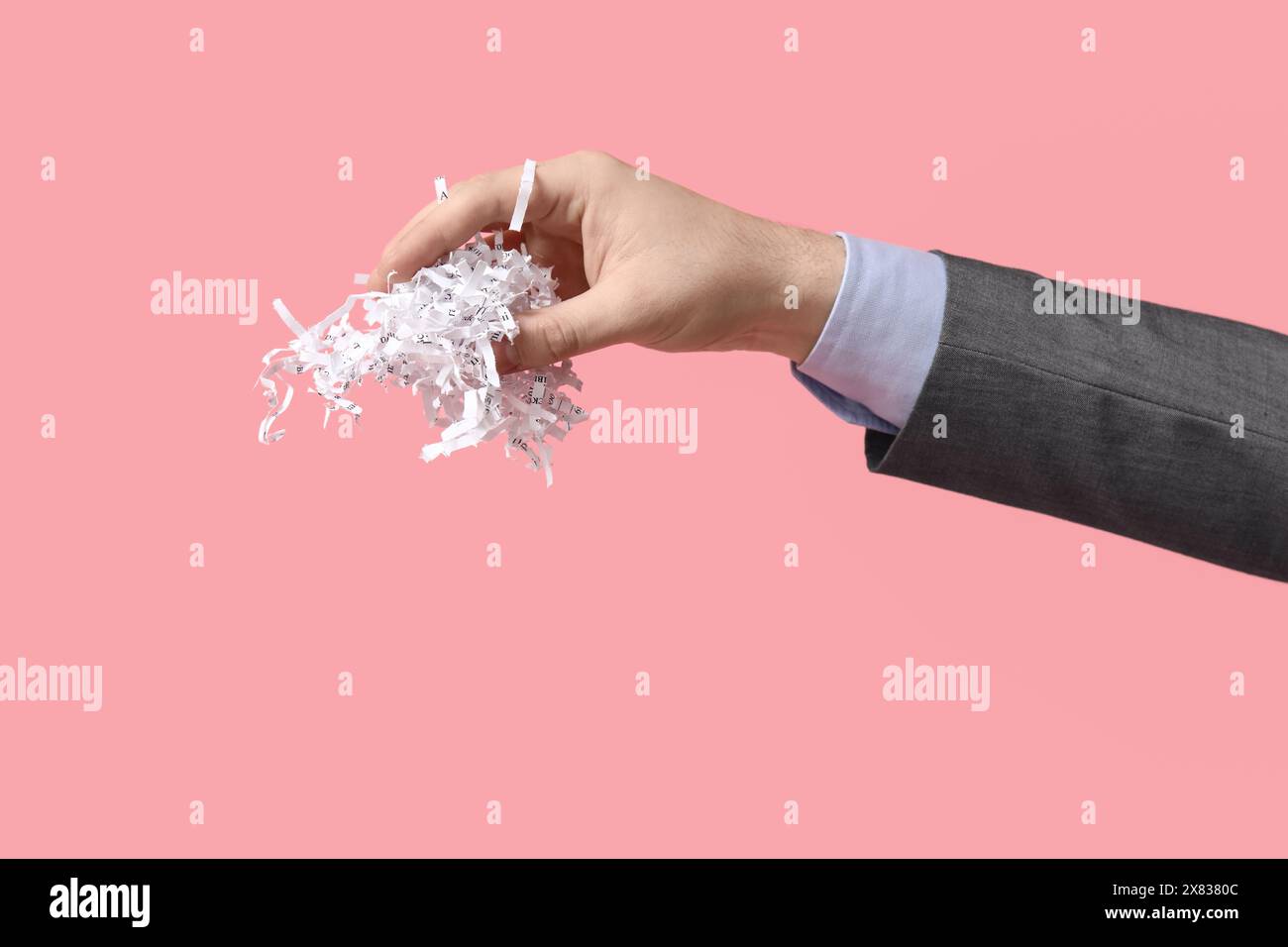 Male hand holding shredded paper on pink background, closeup Stock ...