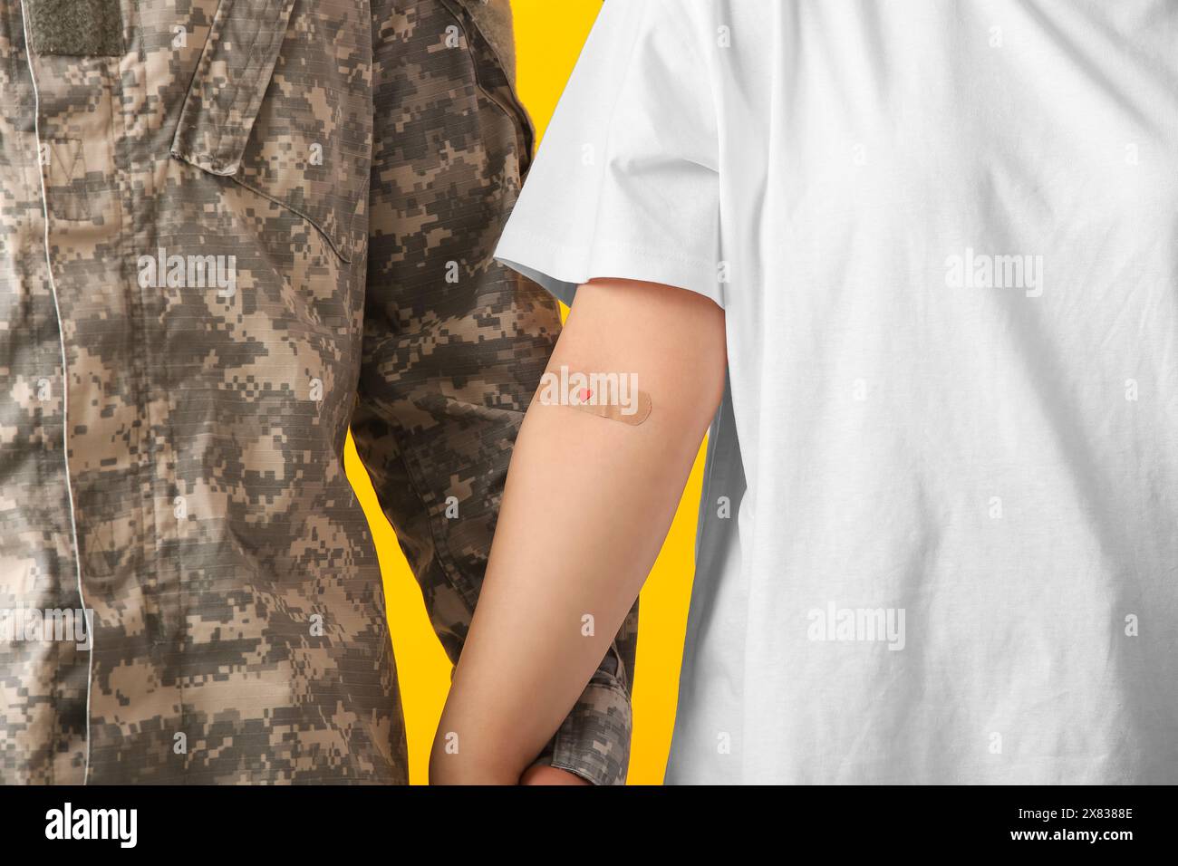 Blood donor with applied medical patch and soldier holding hands on ...