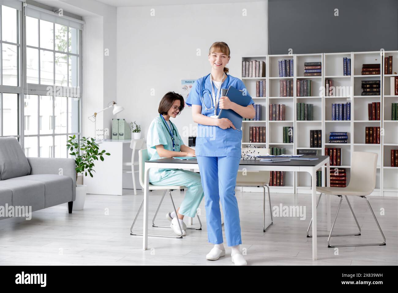 Female medical intern with notebooks in clinic Stock Photo - Alamy
