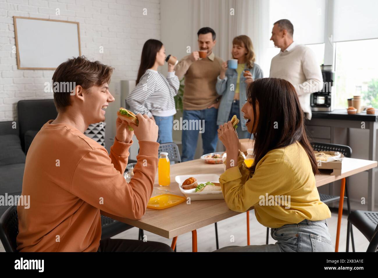 Business people eating sandwiches during lunch at table in office ...