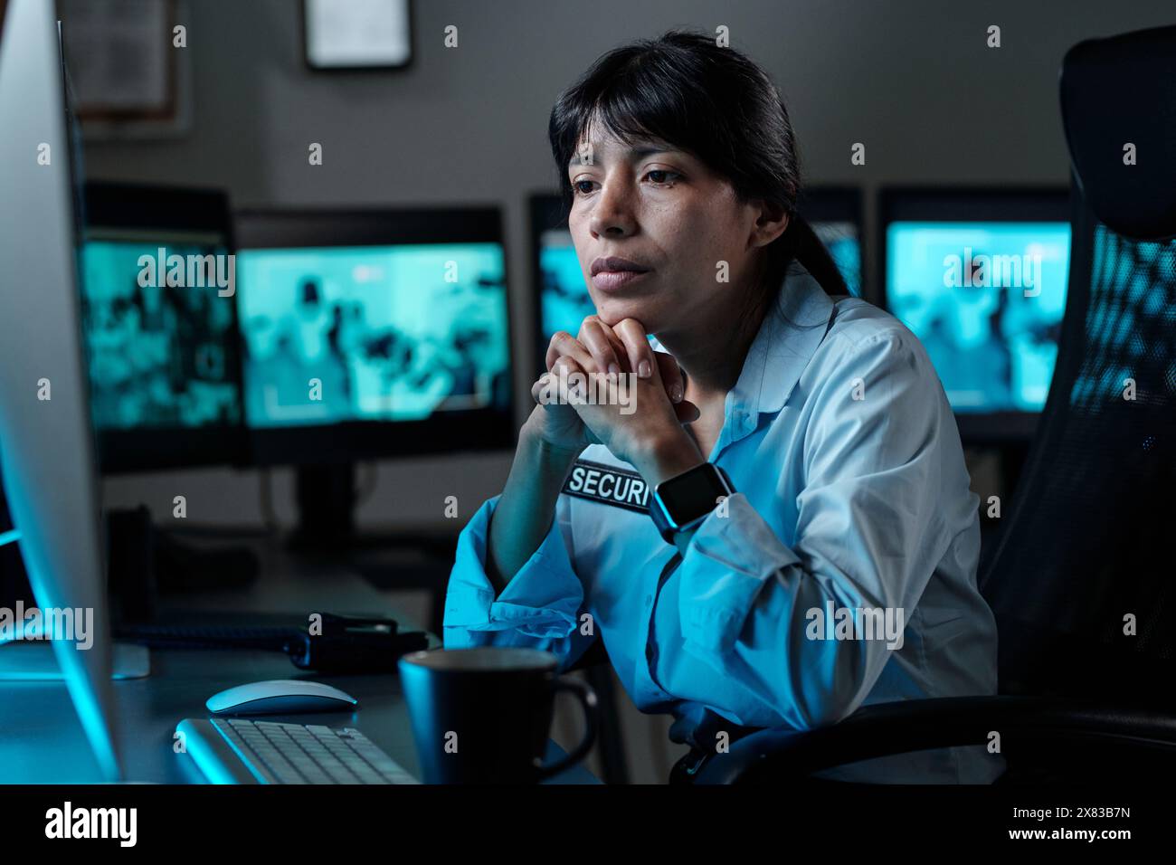Serious young woman in uniform of security guard concentrating on ...