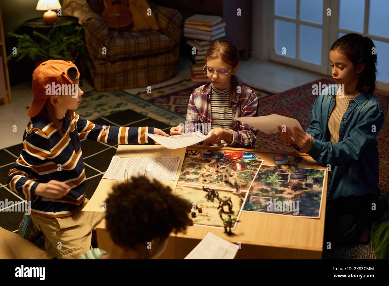 Four cute intercultural children sitting on the floor by table with ...