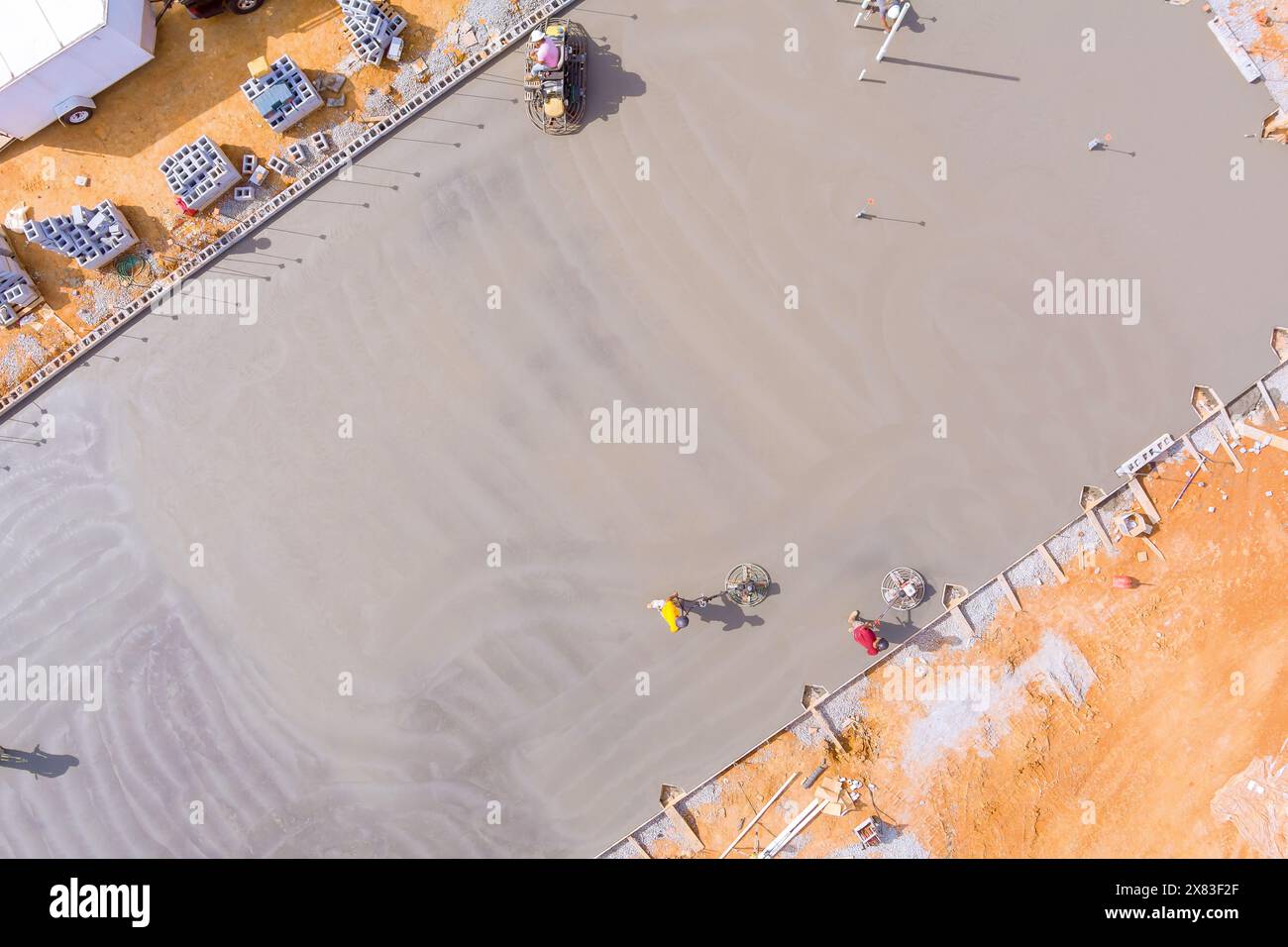 After concrete has been poured, mason works to polish concrete using ...