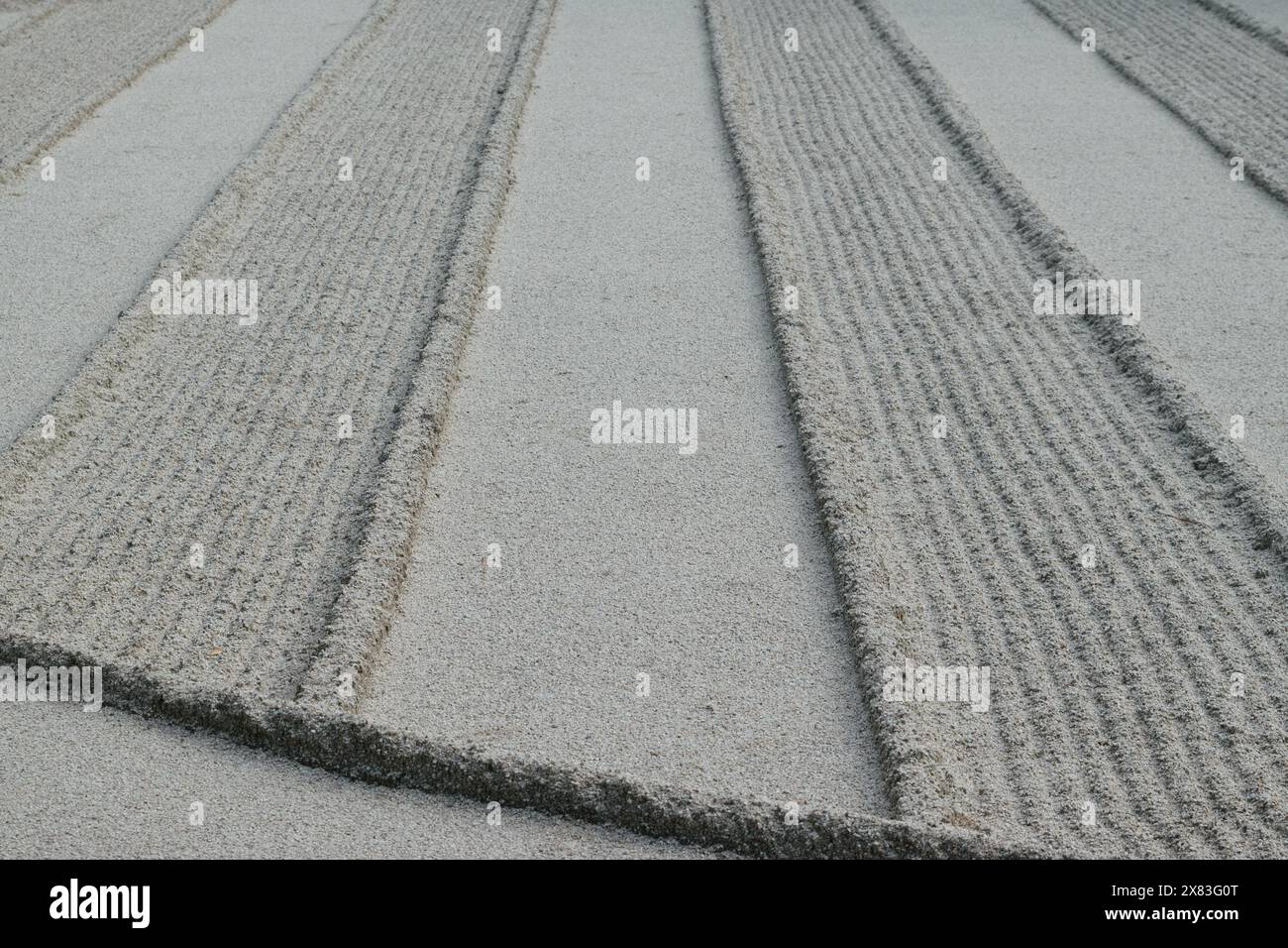 Close-up of a zen garden with meticulously raked sand creating parallel ...