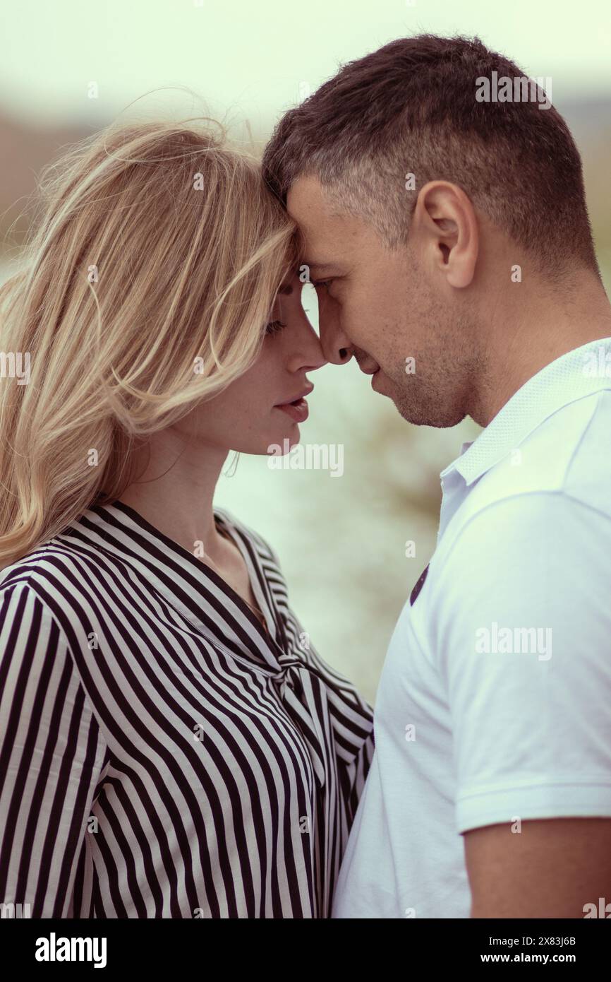 Couple standing forehead to forehead by the river Stock Photo - Alamy