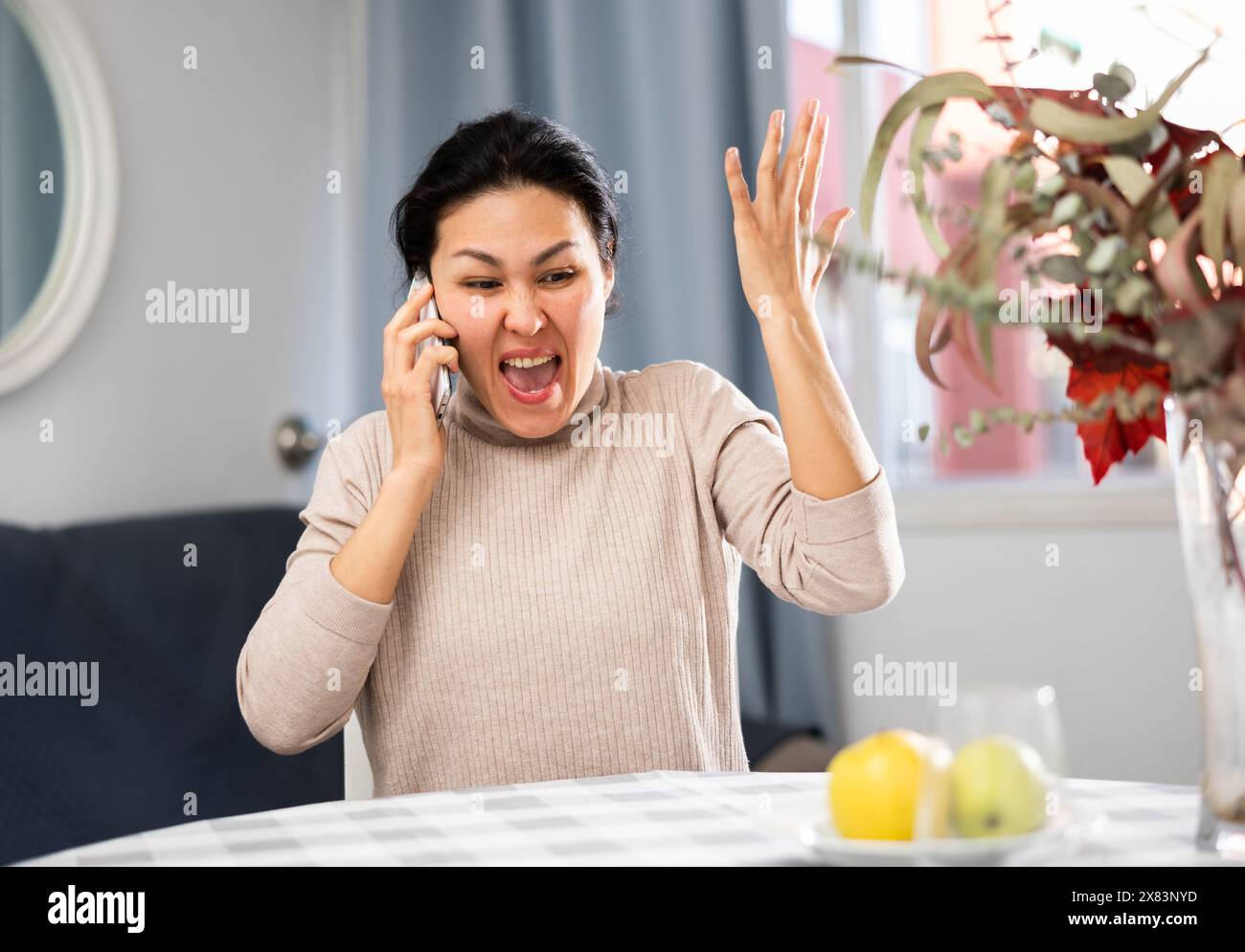 Angry woman arguing while having telephone conversation Stock Photo - Alamy