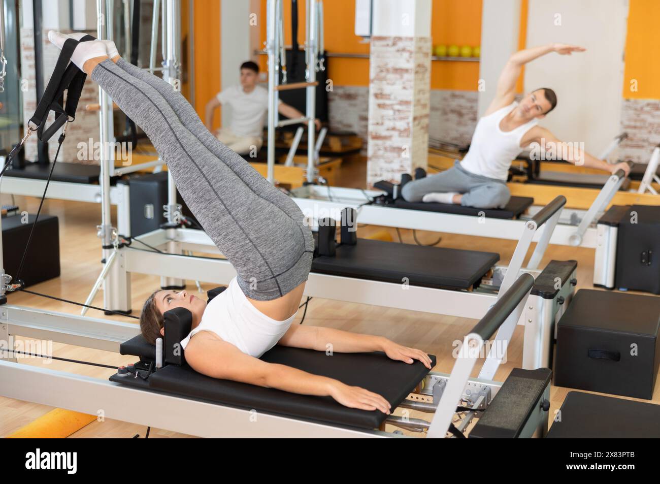 Girl performing reverse crunches with legs lift on Pilates reformer ...
