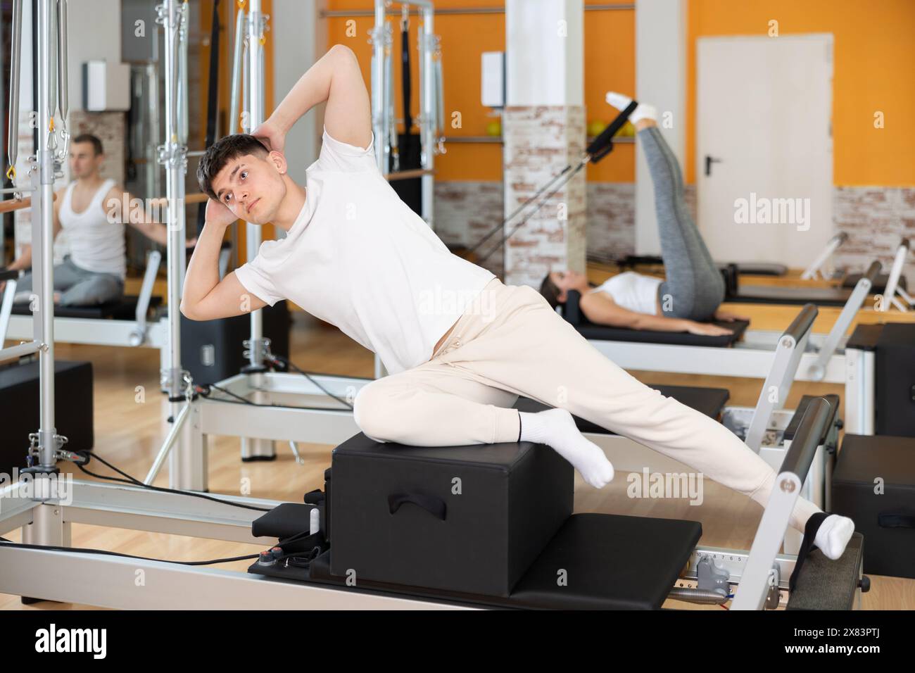 Guy performing exercises on Pilates reformer with sitting box Stock ...