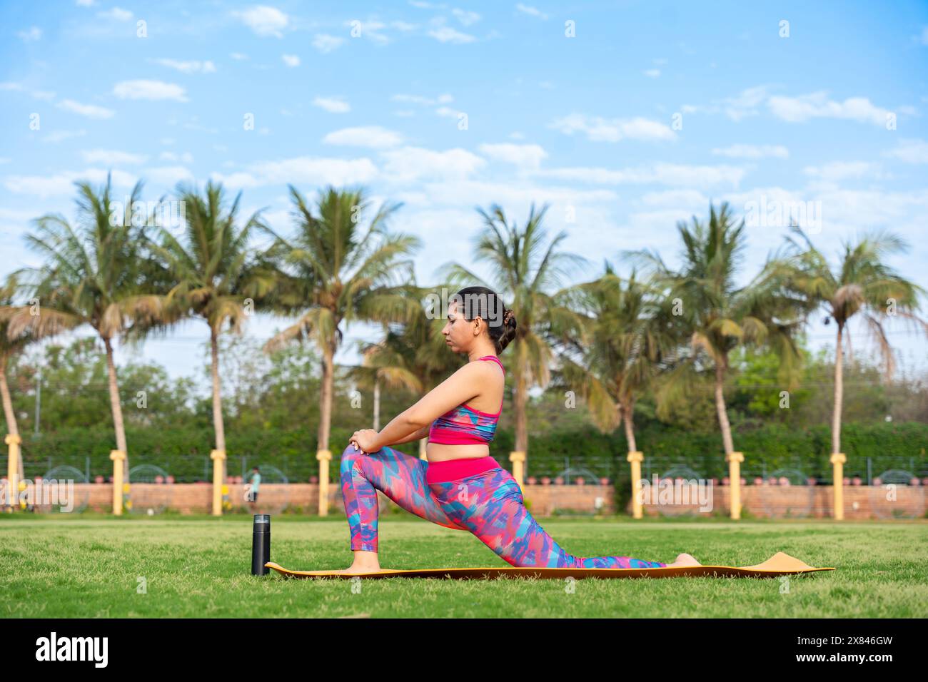 Young indian woman doing leaning forward fold Yoga Pose in her garden ...