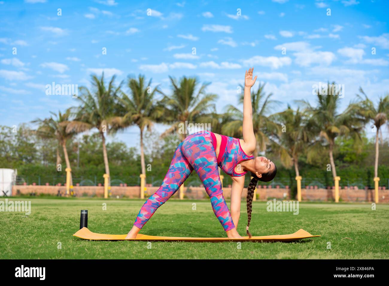 Young indian woman doing Triangle , Utthita Trikonasana yoga pose in ...
