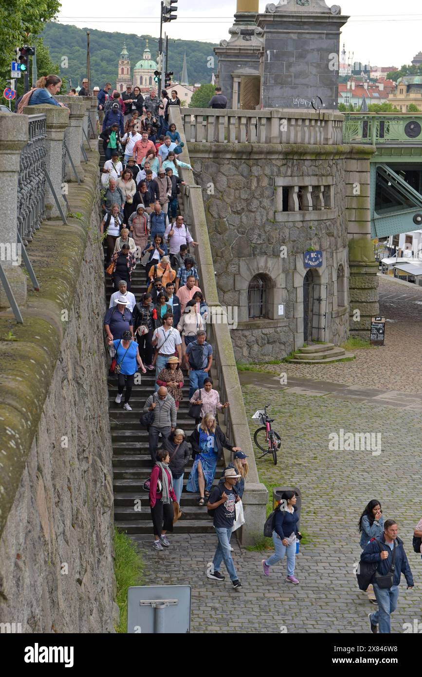 Tourist groups crowd steps next to Čechův Most or Svatopluk Čech bridge ...