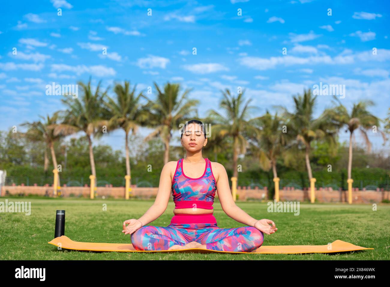 fit young indian woman doing Lotus Pose , Padmasana yoga pose in garden ...