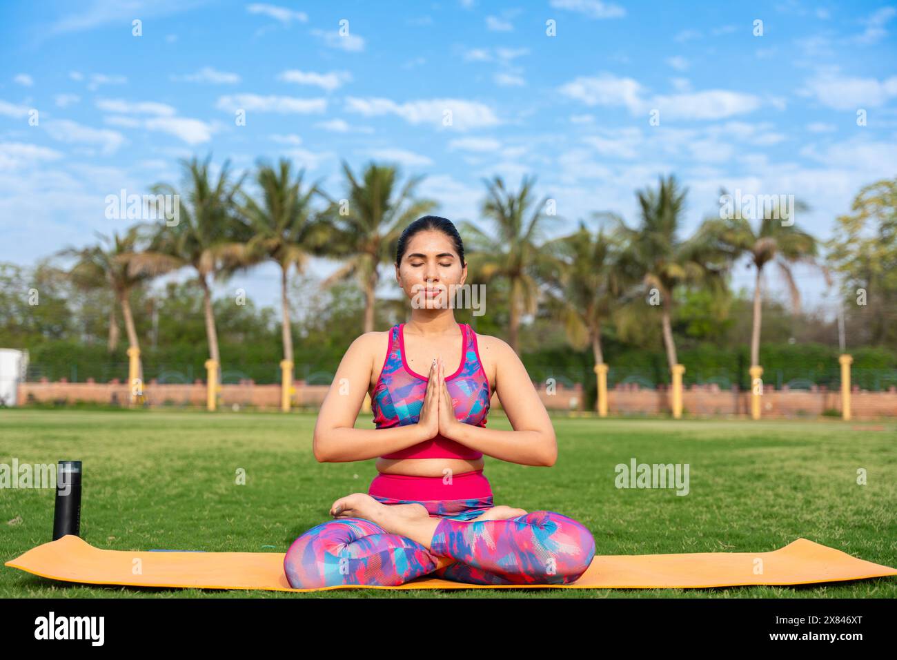 Fit young indian woman practicing surya namaskar yoga pose in garden ...