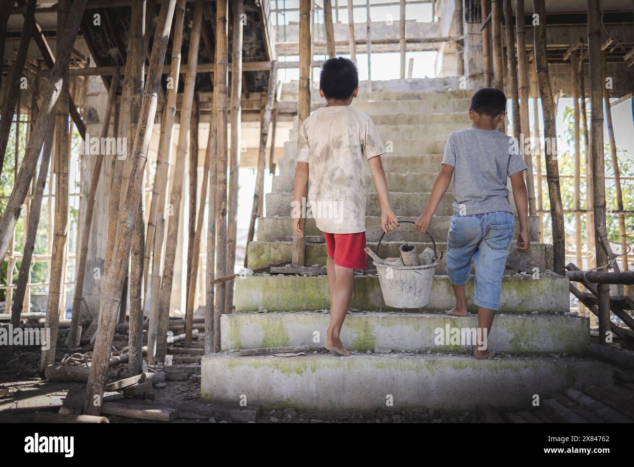 Two poor children are forced to work in construction. Poor children ...