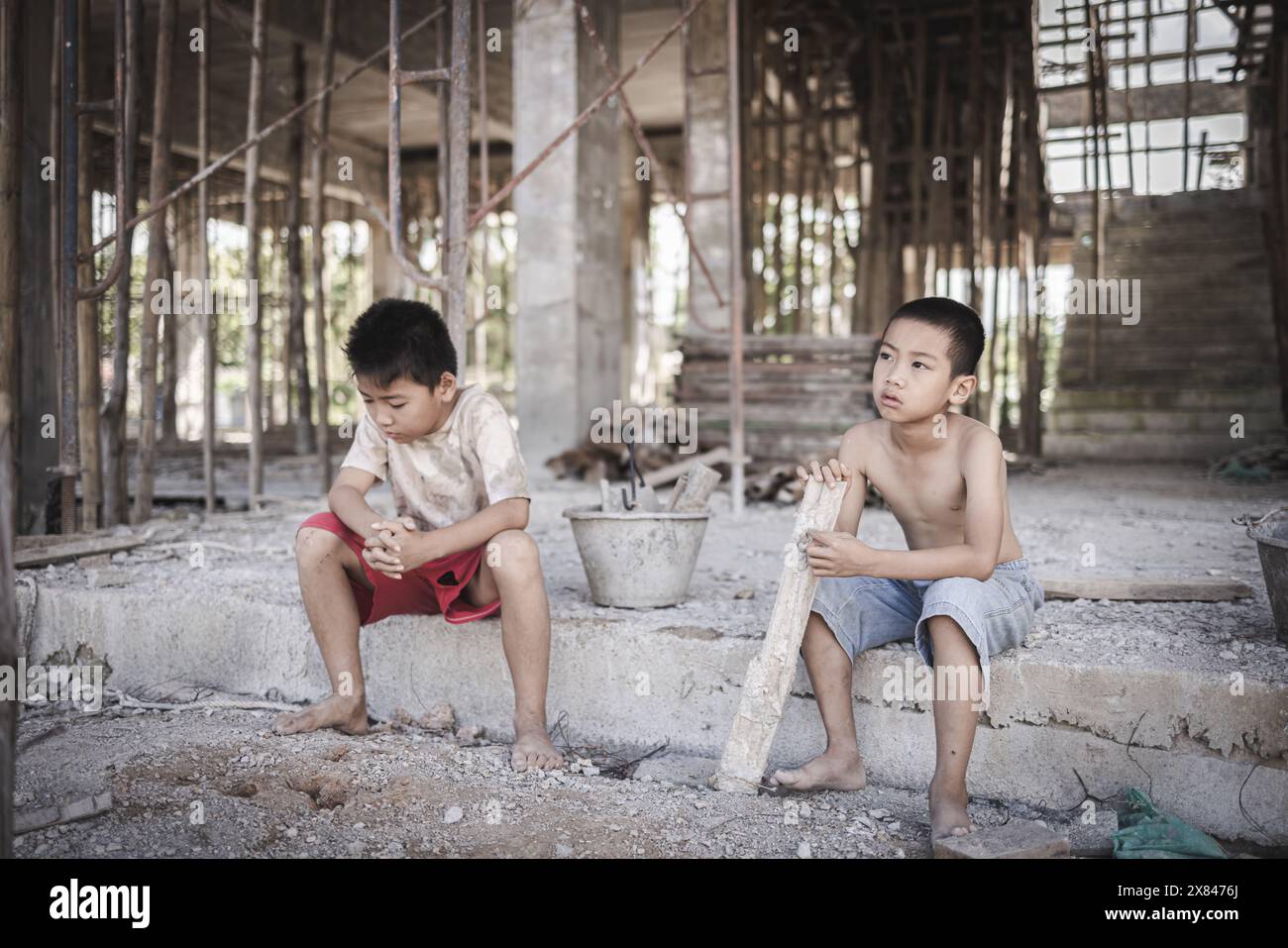 Two poor children are forced to work in construction. Poor children ...