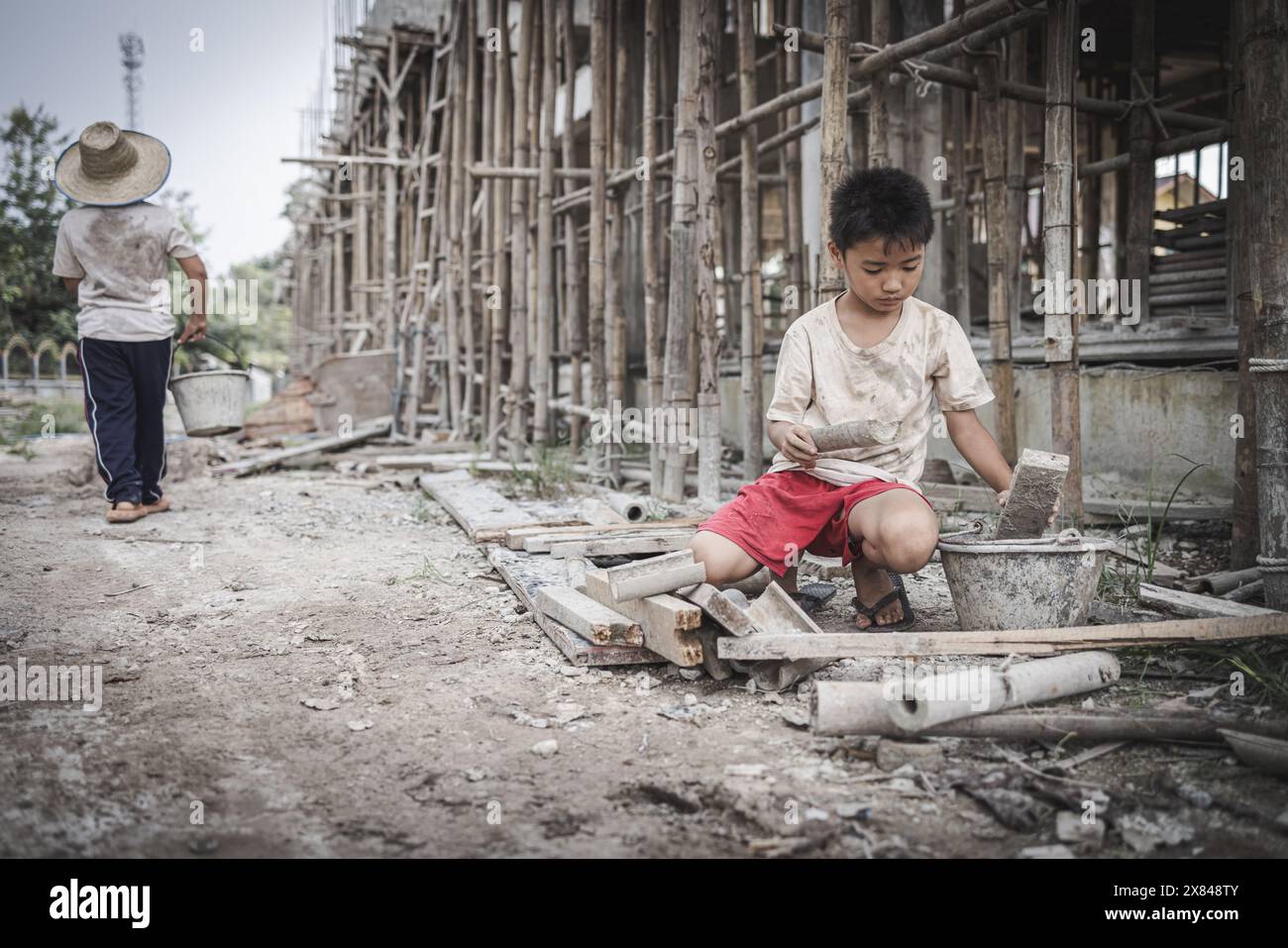 Two poor children are forced to work in construction. Poor children ...