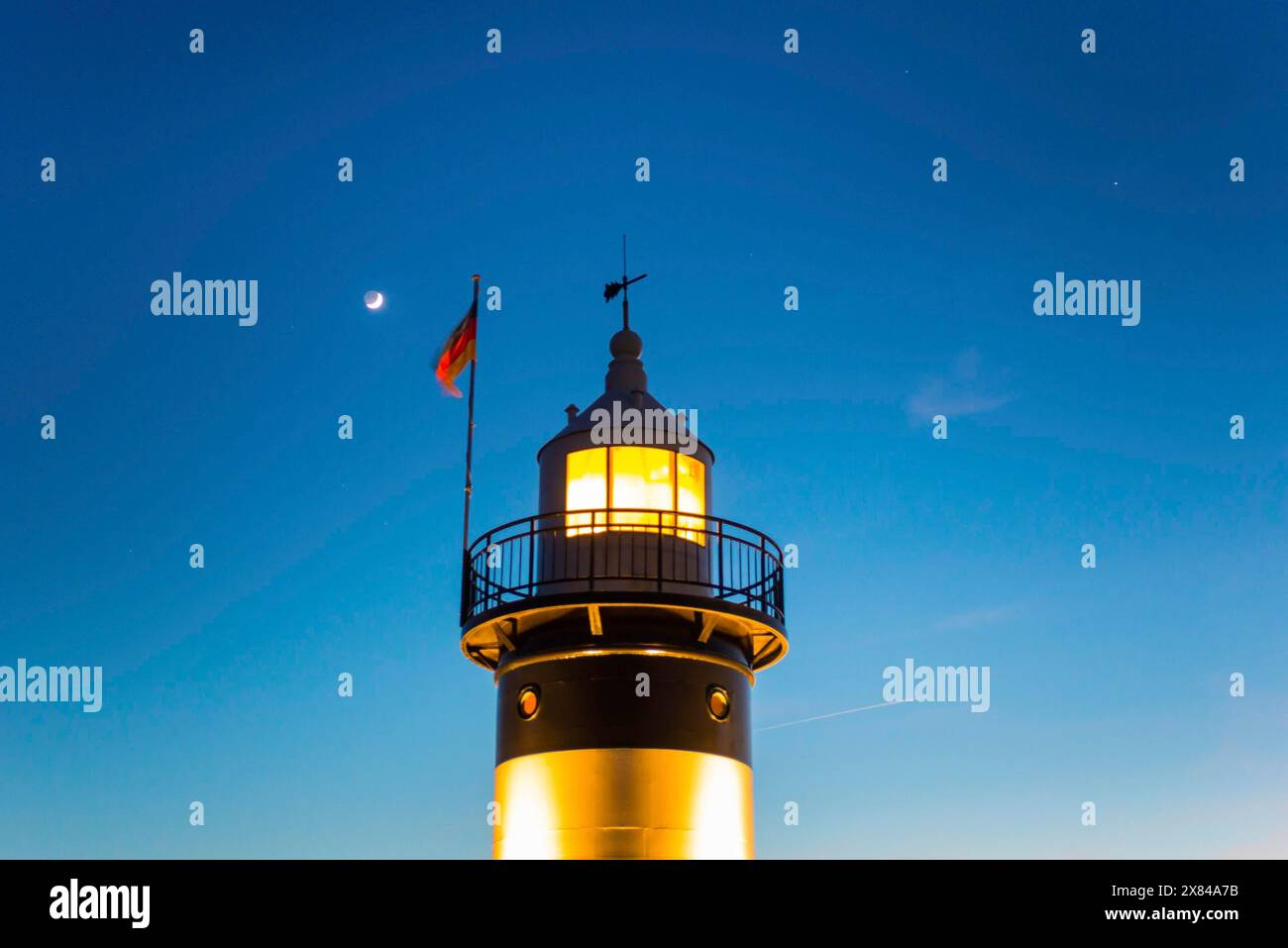 Upper segment of an illuminated lighthouse at night, black and white ...