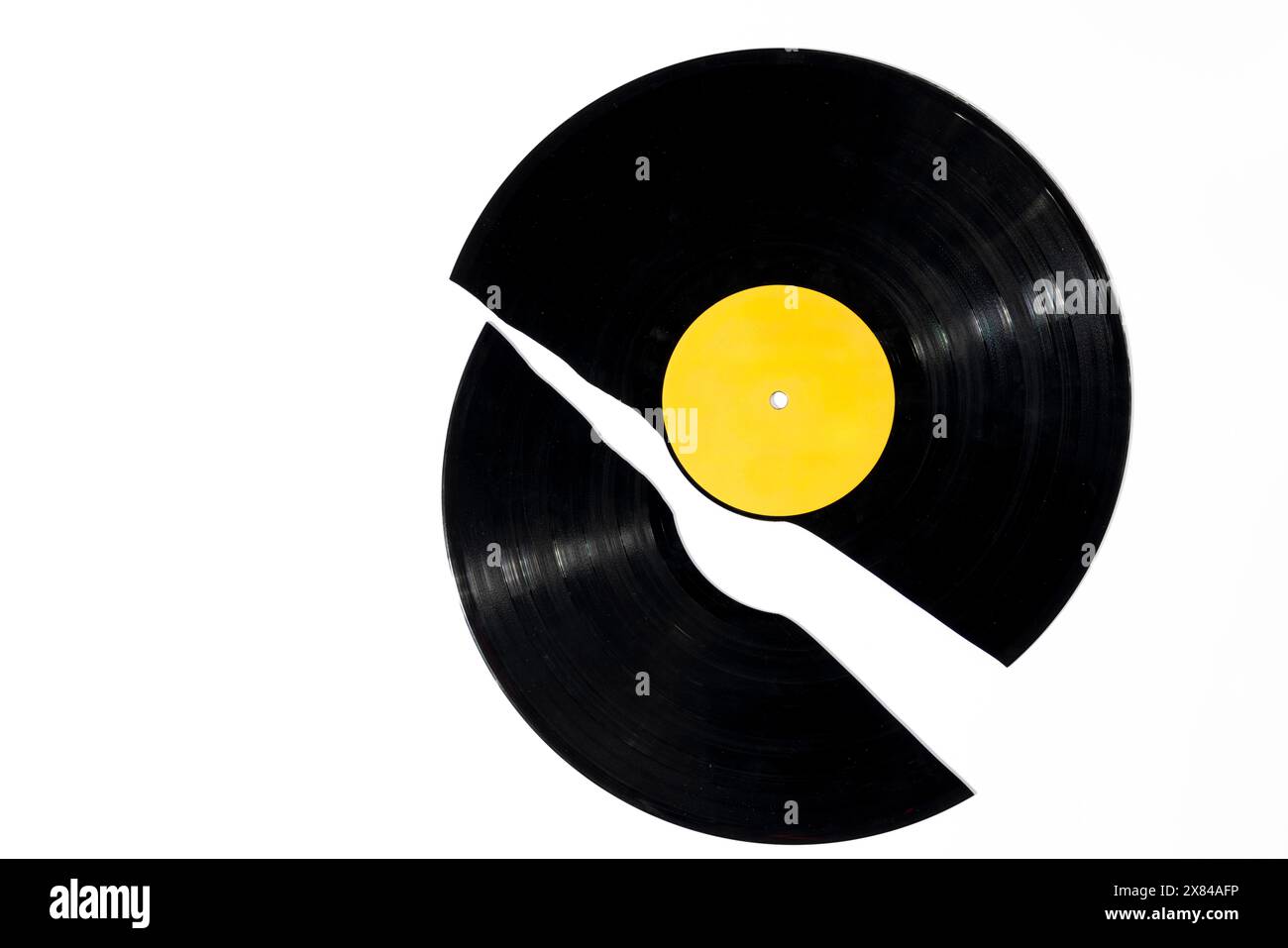A black record with a yellow label that is broken in two Stock Photo ...