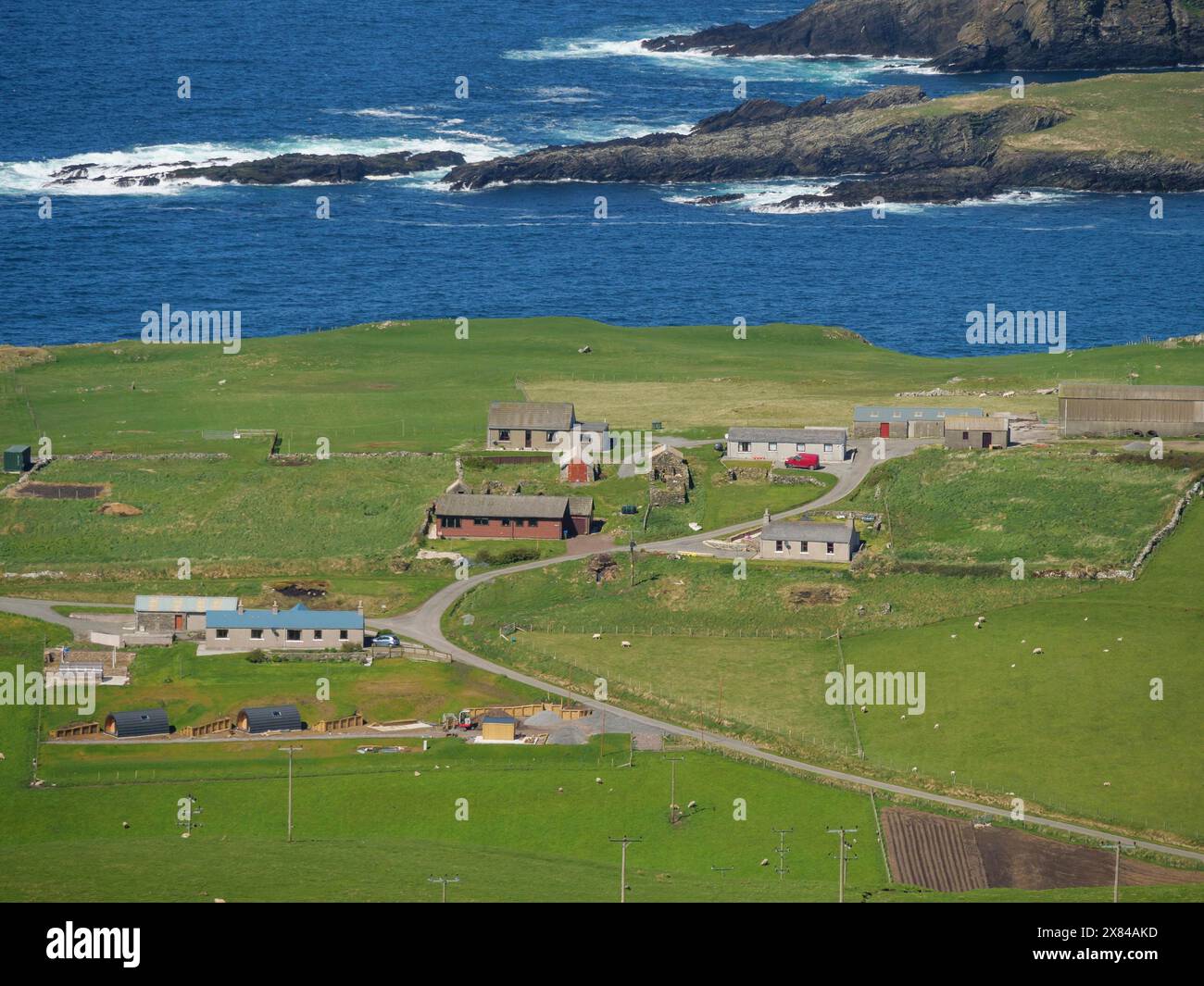 Small cluster of houses in rural area by the sea with cliff top views ...