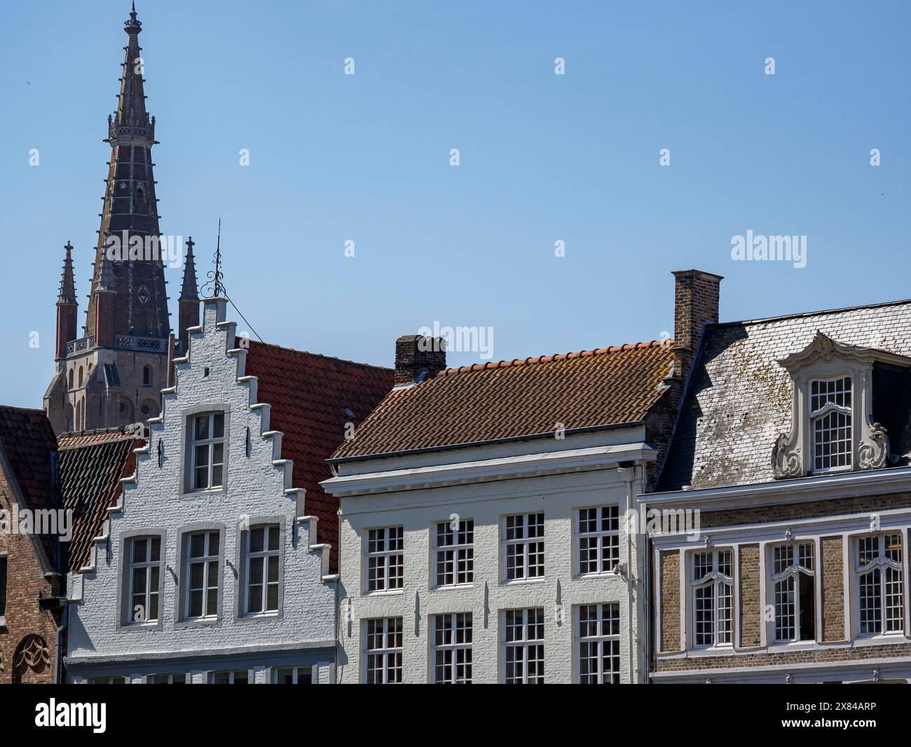 Historic buildings with gables and a church in the background under a ...