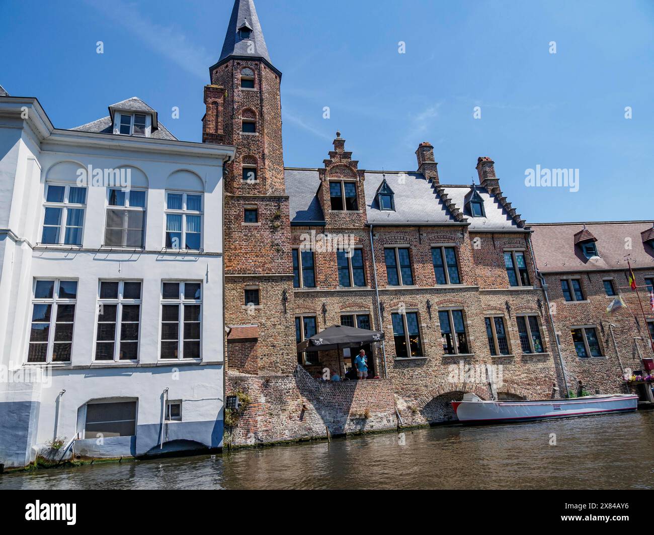 Old gothic style buildings next to a canal with a boat, captured on a ...