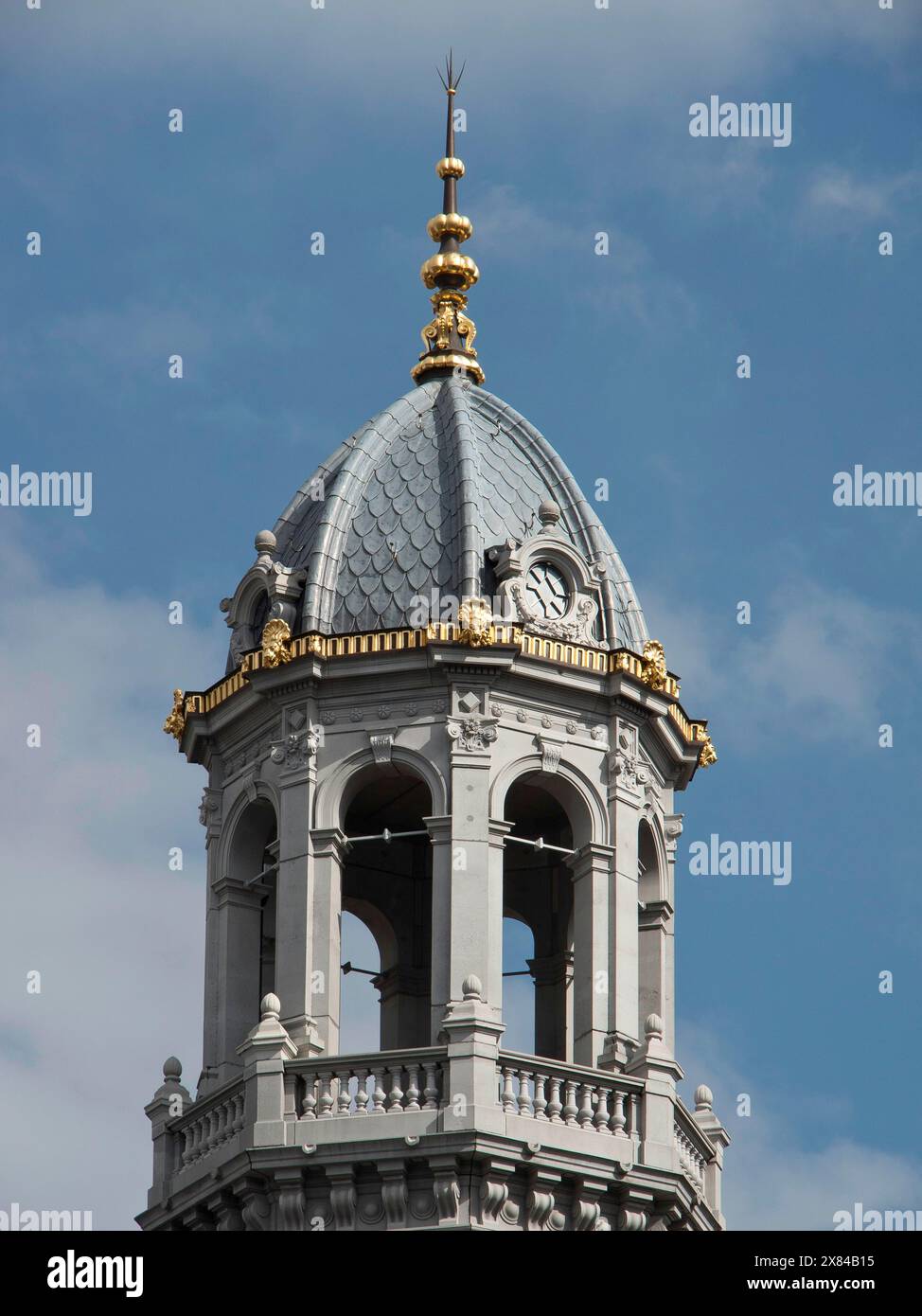 Classic bell tower with dome and golden decorations against a cloudy ...