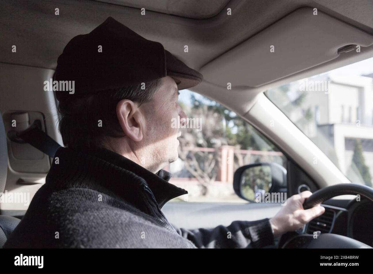 A man drives a car around the city. View from the inside of the car ...