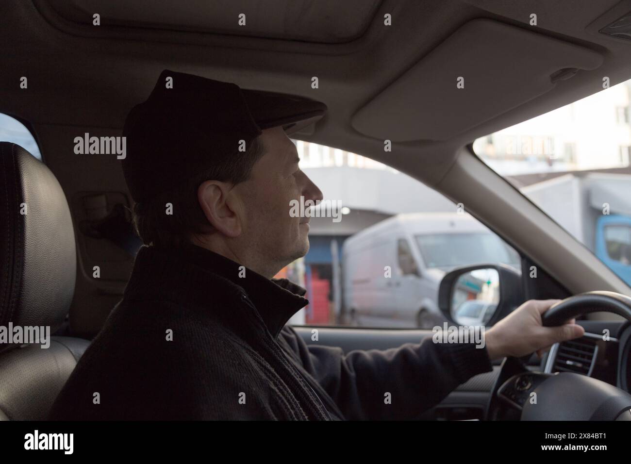 A man drives a car around the city. View from the inside of the car ...