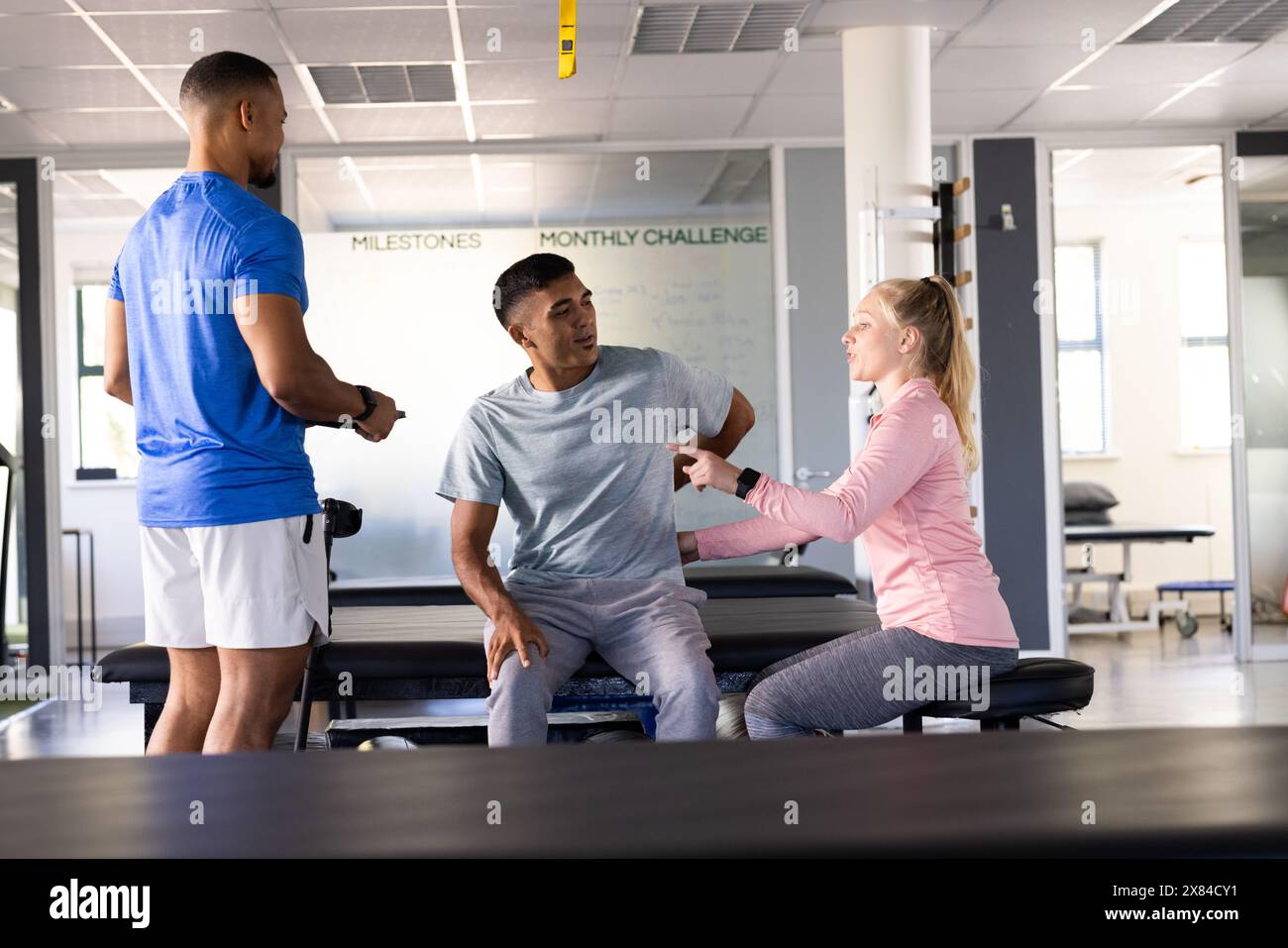 At rehabilitation center, diverse physical therapists helping biracial ...