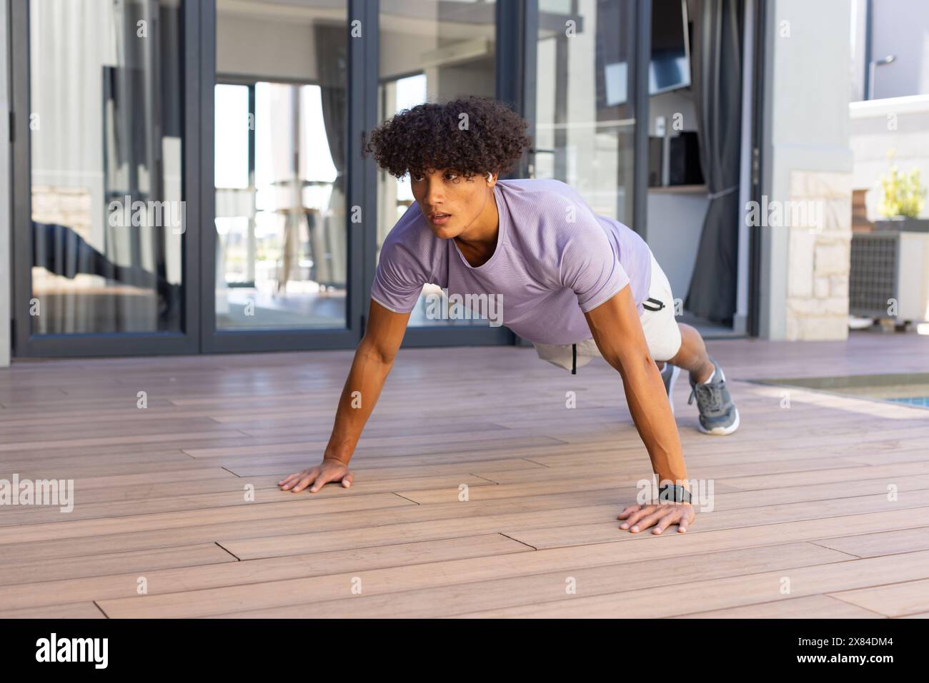 A biracial young male wearing purple, exercising outdoors Stock Photo ...