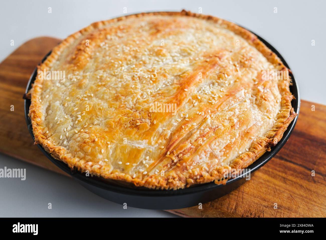 homemade round puff pastry pie in style of a sheperd's pie with sesame ...