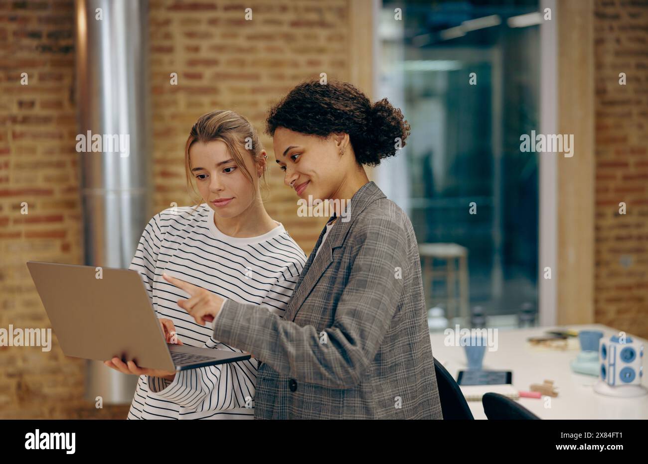 Two business woman work together to get the job done at the office and ...