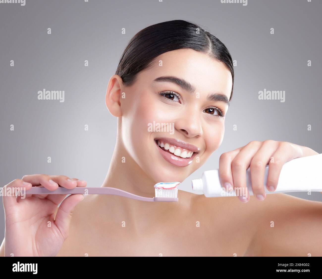 Portrait, woman and brushing teeth with smile, dental hygiene and cavity on grey studio ...