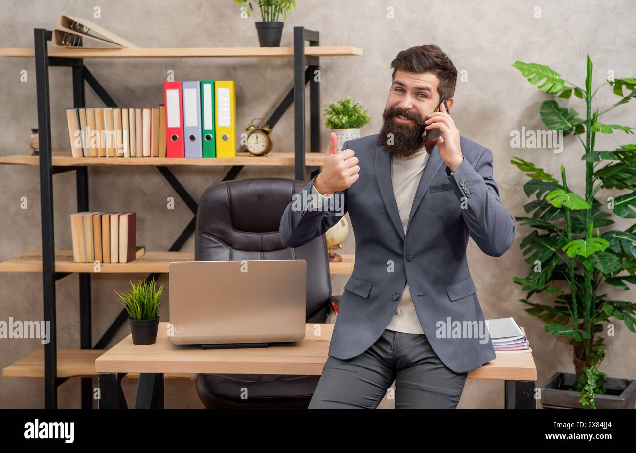 Giving thumbs up. Happy manager talking on phone show thumb gesture ...