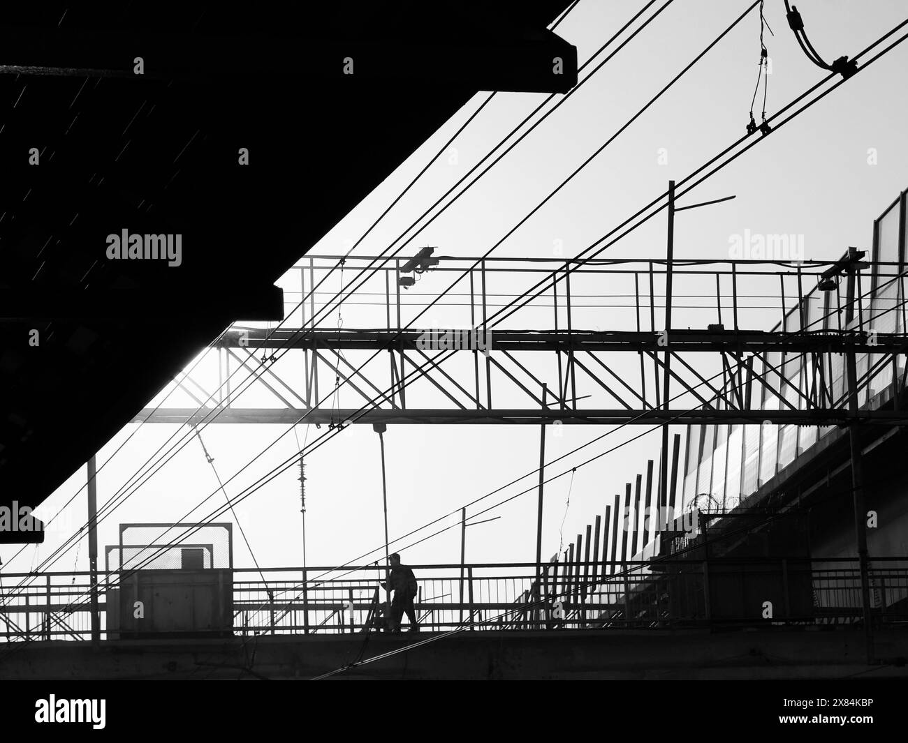 Black and white image of a worker on a bridge at a construction site ...