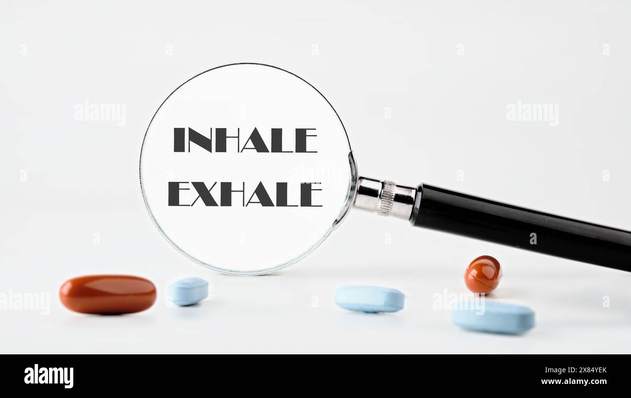 INHALE EXHALE written words through a magnifying glass on a light ...
