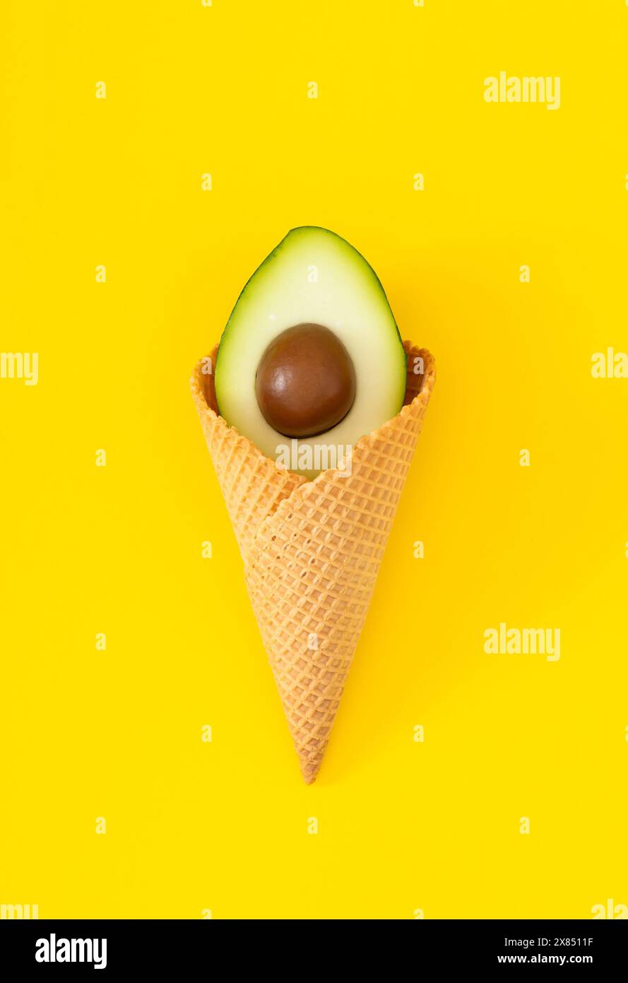 Ice cream cone with fresh avocado on bright yellow background. Minimal ...