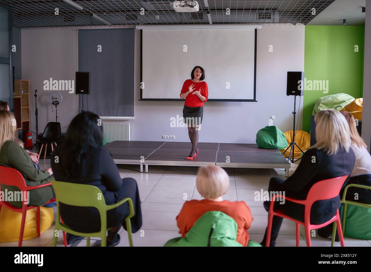 woman giving emotional speech on stage, performance hall in office ...