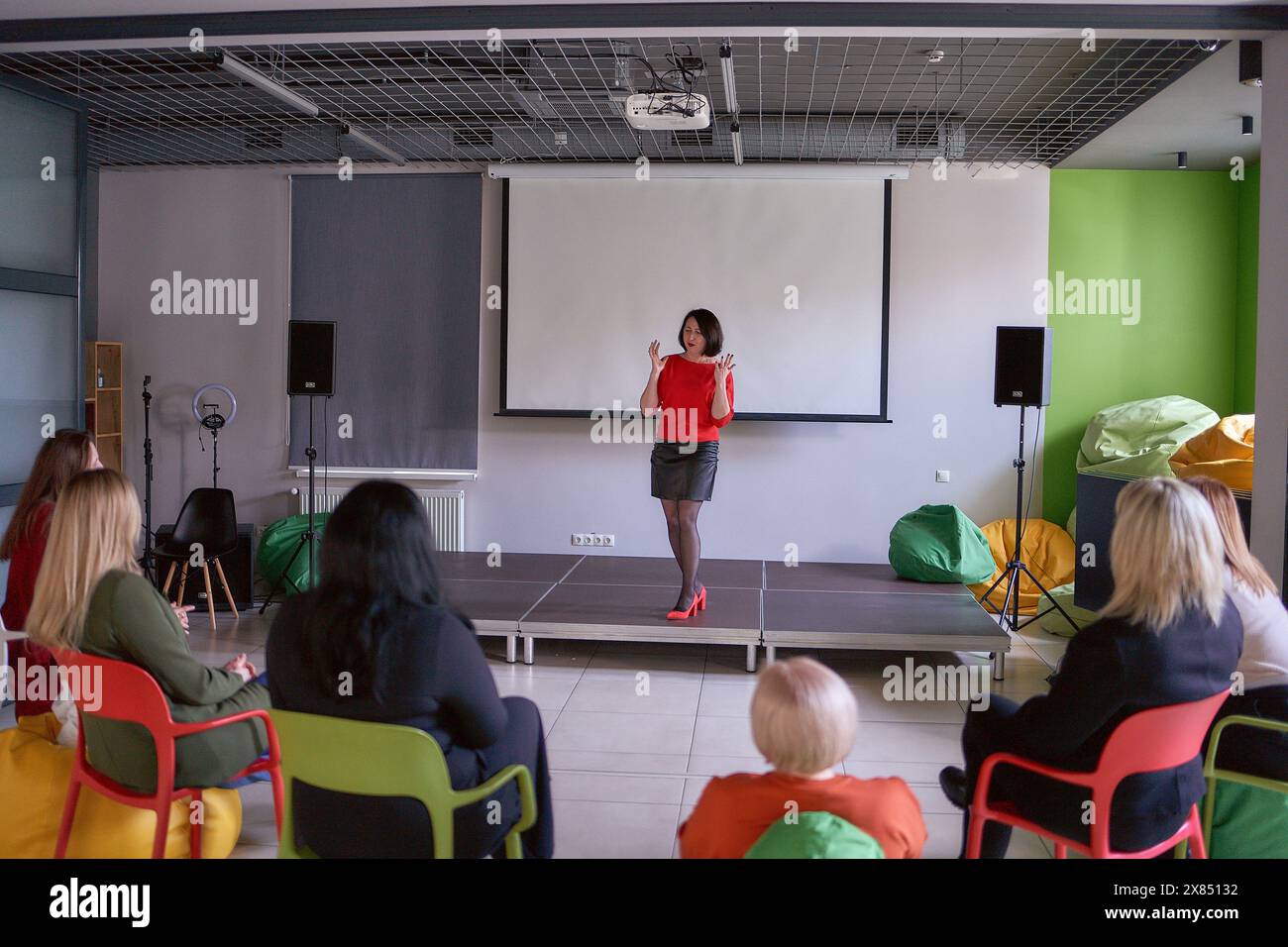 woman giving emotional speech on stage, performance hall in office ...