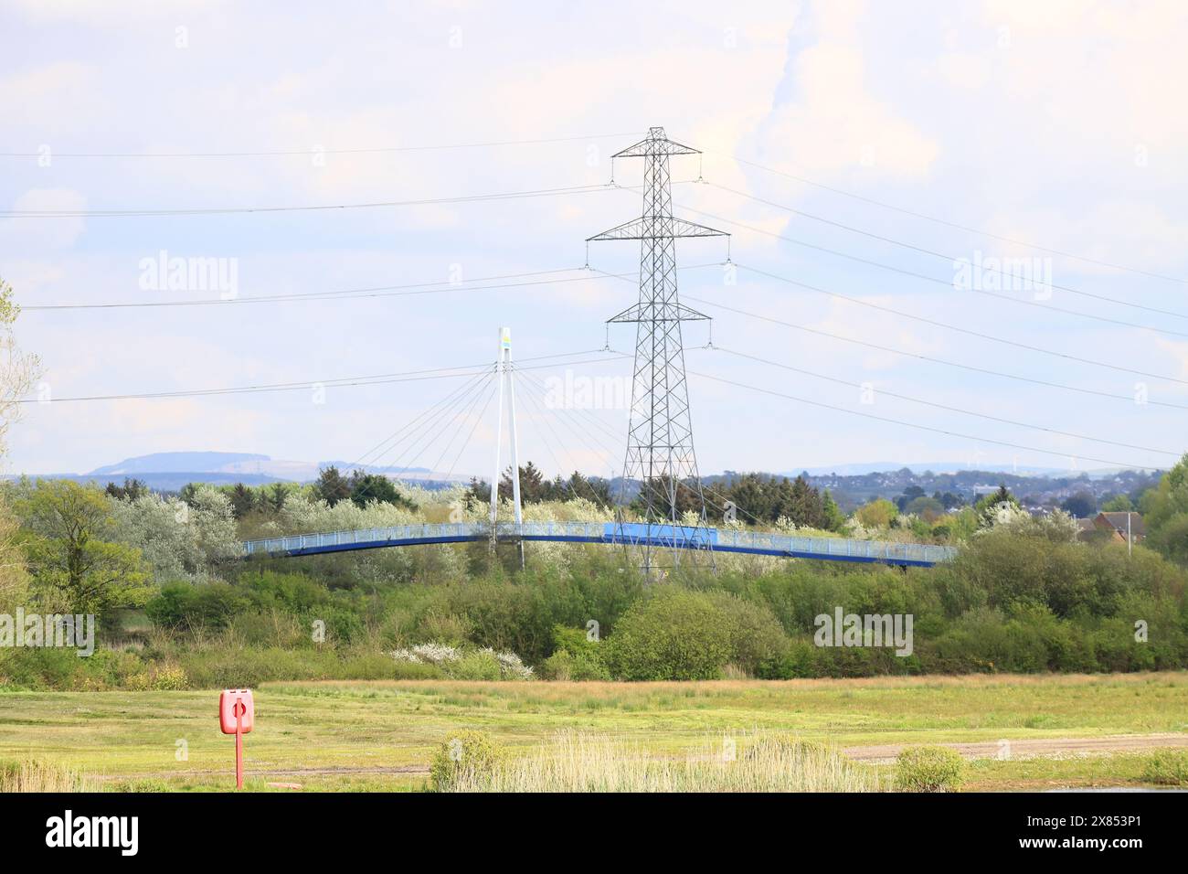 A pylon and a narrow bridge in a tree-lined landscape. 27 April 2024. A ...