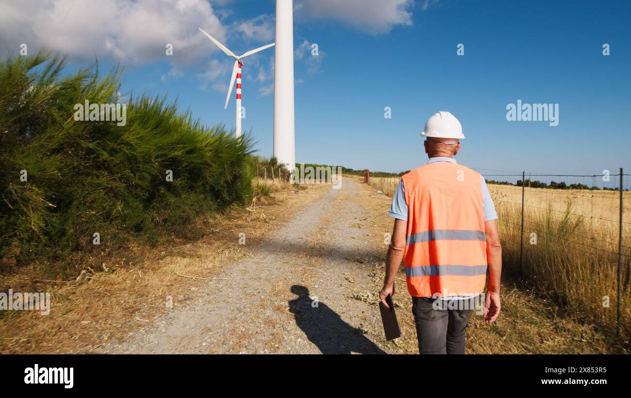 Engineer Walking Under Wind Turbines Stock Photo - Alamy
