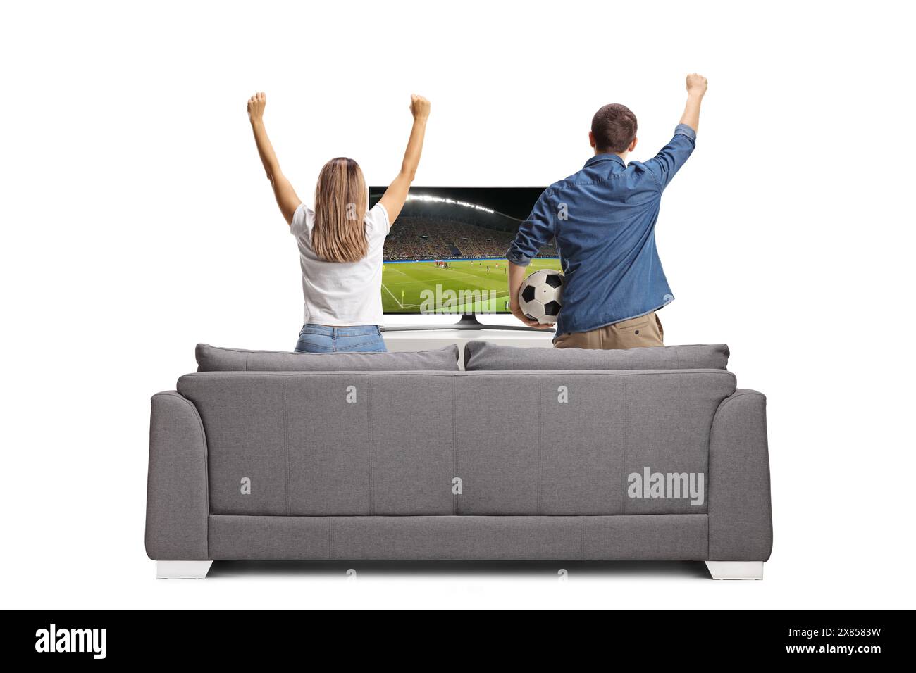 Excited young couple watching a football match on tv and cheering ...