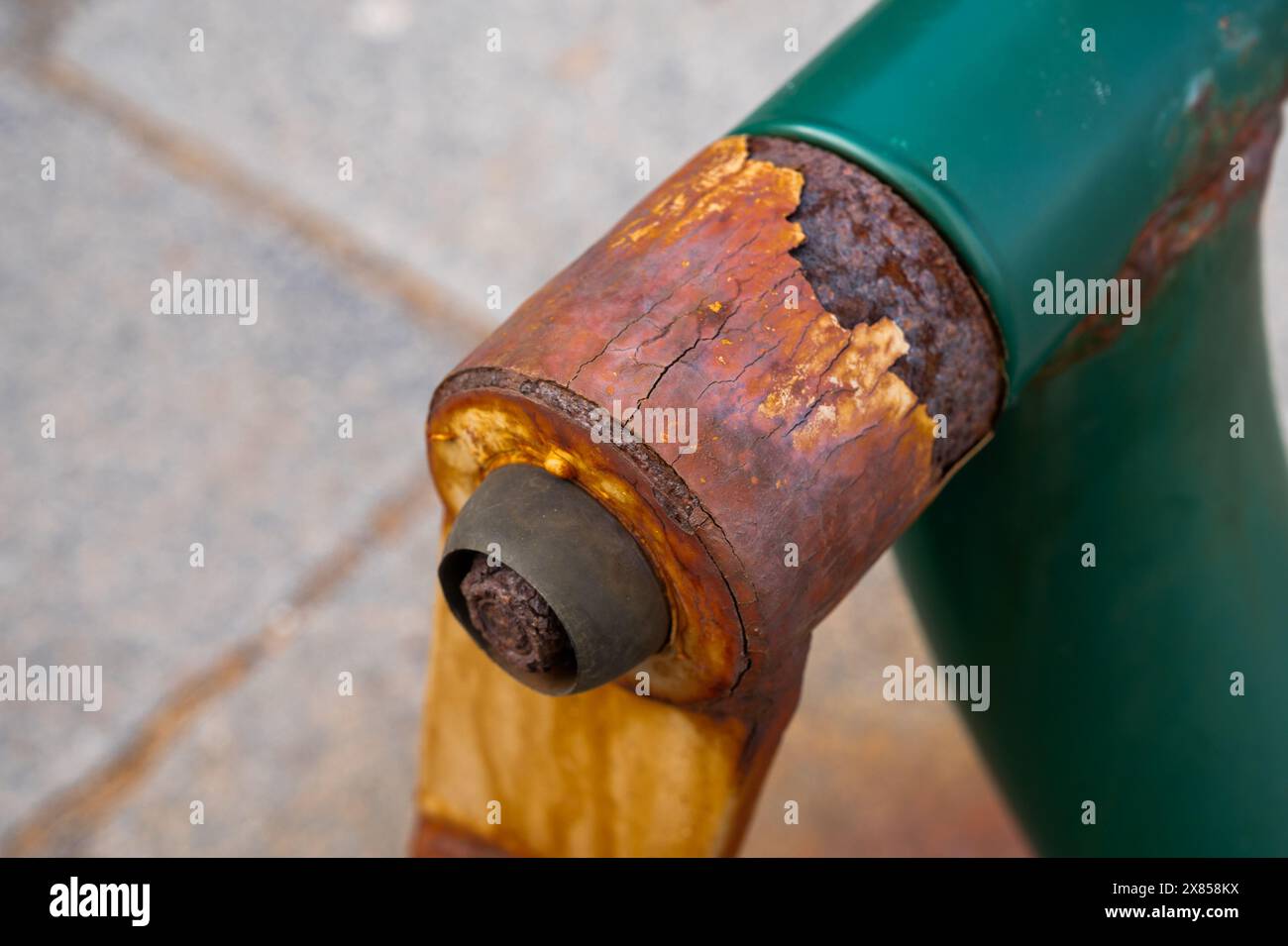 A green bench with a rusted bolt on the back. The bolt is missing and ...