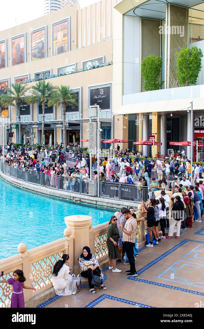A crowd of tourists waiting for the Dubai Fountain show in Dubai Mall ...