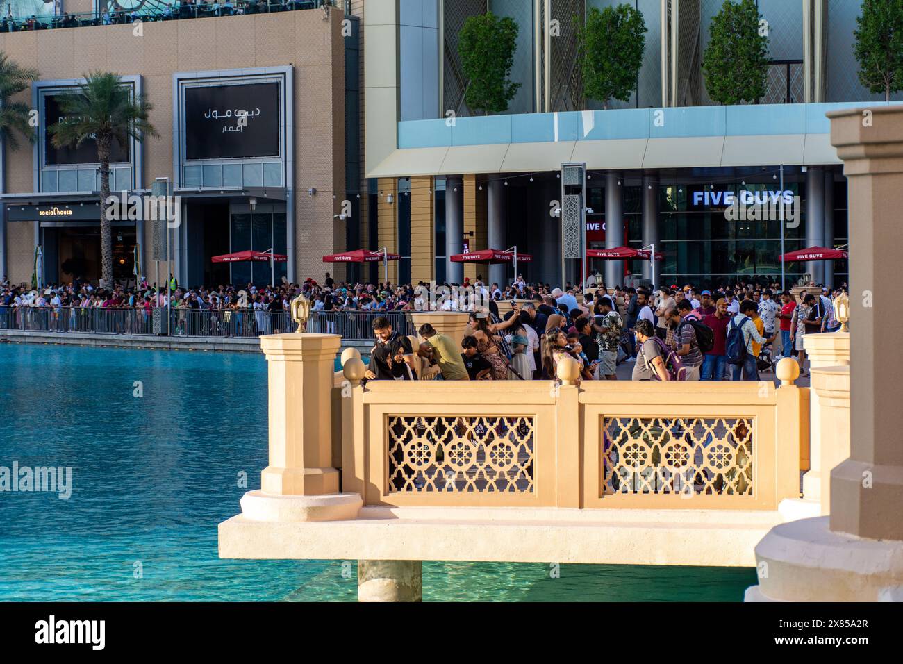 A crowd of tourists waiting for the Dubai Fountain show in Dubai Mall ...