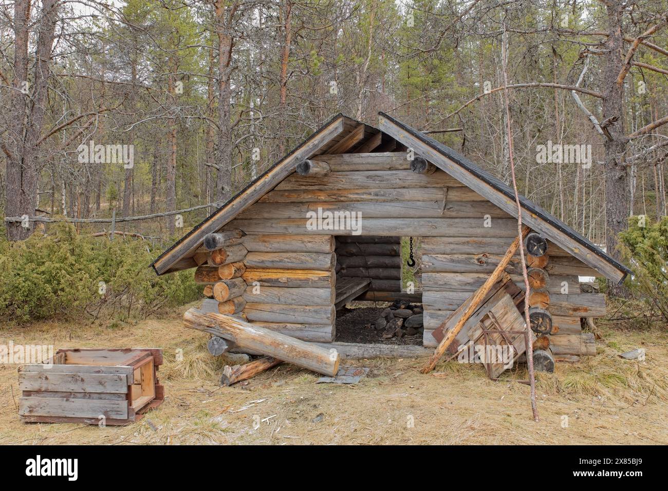 Old log shelter and fireplace in cloudy spring weather at Riutukka Log ...
