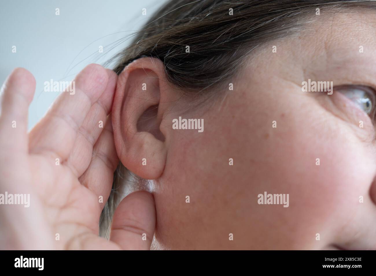 caucasian mature woman difficulty hearing, cerumen impaction, hearing loss, medical concept ...
