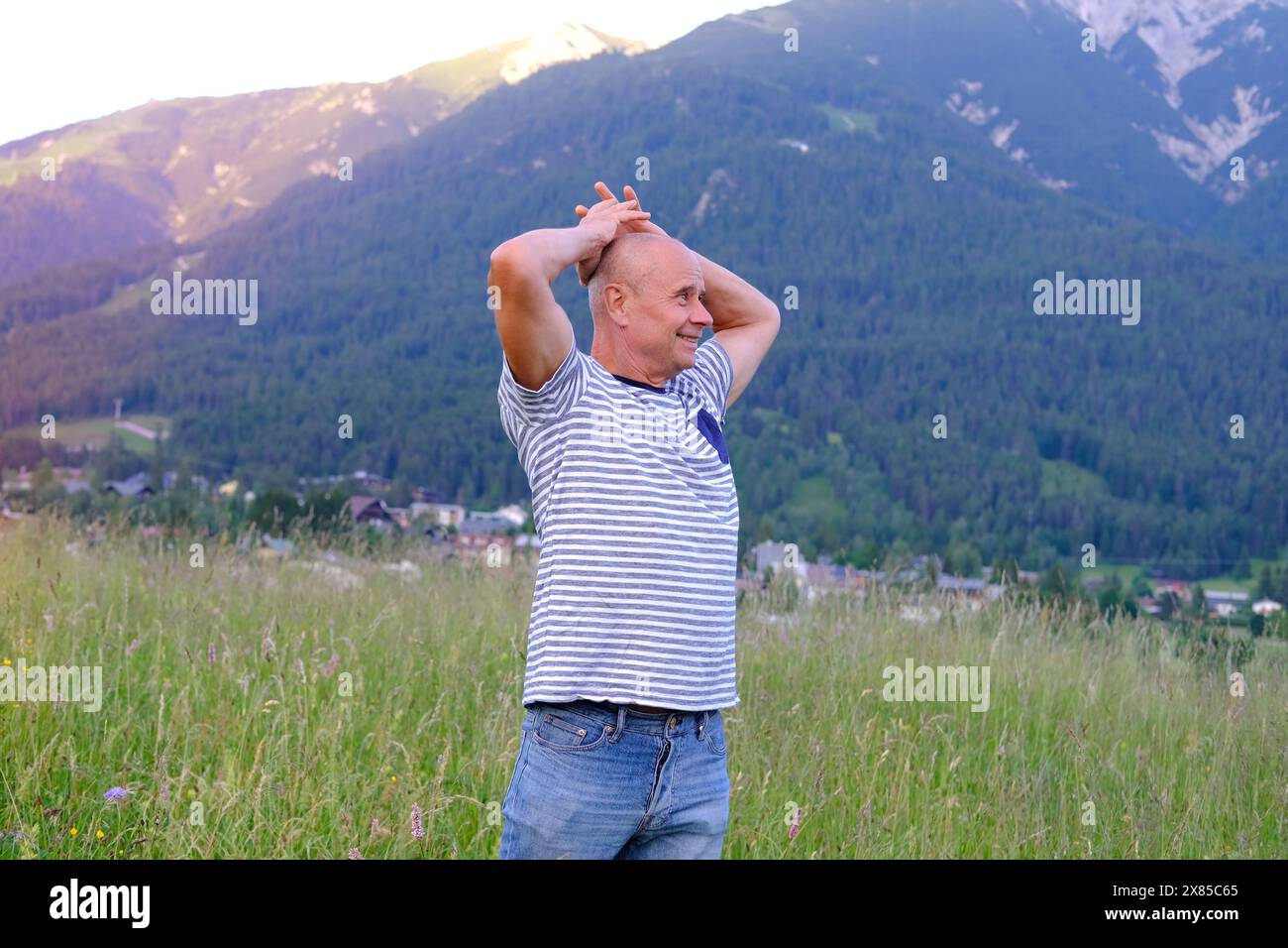mature man, senior 60 years old standing in mountains above city ...